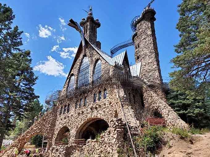 The stone fortress stands proud against blue skies, proving one person's vision can literally reach the heavens above.