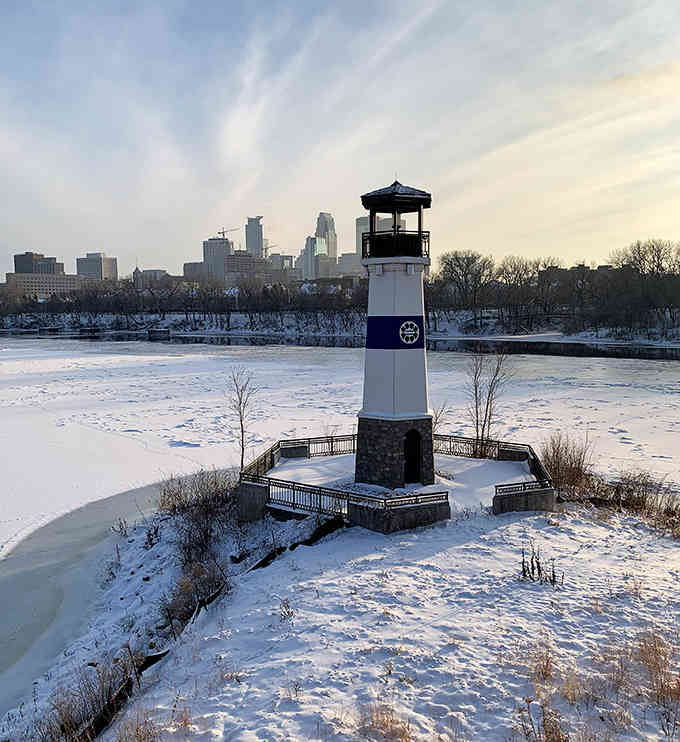Winter transforms the riverfront beacon into a snow-globe scene, with downtown's skyline providing a stunning urban backdrop.