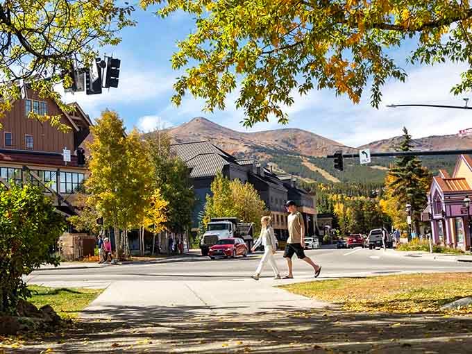 Autumn leaves frame a mountain street where couples stroll as casually as if they're walking through a Bavarian postcard.