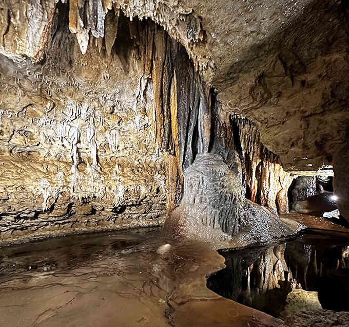 Stalactites hang like frozen chandeliers while mineral-rich water continues its ancient work of sculpting stone into wonder.