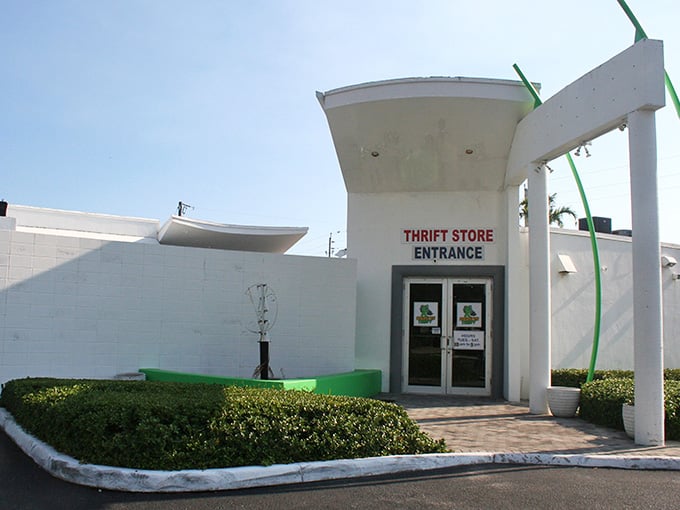 Manicured hedges and pristine white walls create an upscale atmosphere where secondhand shopping feels first-class.