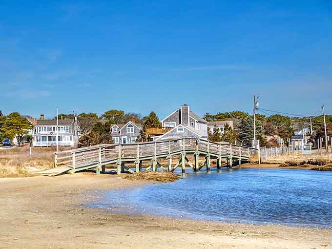 A weathered pier stretches toward classic Cape homes, connecting land and sea like old friends catching up over coffee.