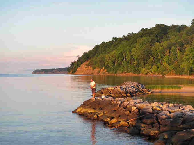 Golden hour turns this rocky shoreline into a fisherman's paradise where patience meets the Potomac's gentle waves.