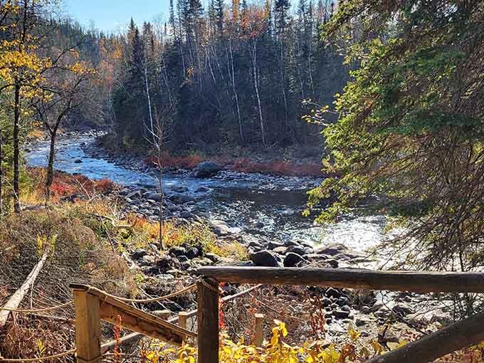 Fall colors frame the rushing river below, creating a scene worthy of any postcard.
