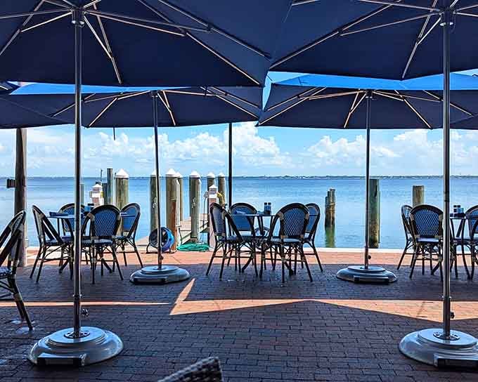 Blue umbrellas frame the endless bay view where water meets sky in that perfect shade of Florida blue.