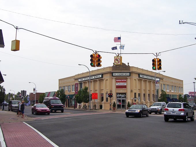 That classic corner building commands attention like the town elder it is, standing firm while traffic lights orchestrate the daily dance.