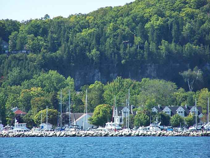 Sailboats dot the harbor below charming homes nestled into green hillsides, creating a postcard that never gets old to see.