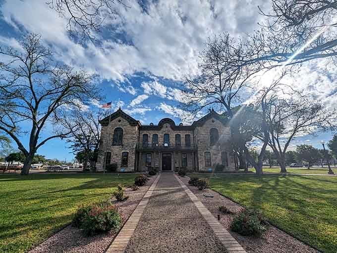 Dramatic clouds hover over this stone courthouse like something from a classic frontier town photograph album.