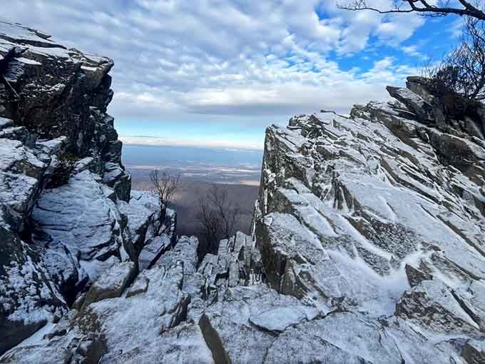 Snow-dusted rocks frame a winter vista so dramatic it could make a postcard jealous of its own scenery.