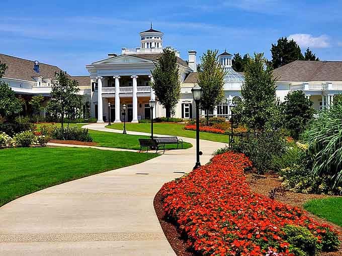 Brilliant red blooms line the walkway to this grand entrance, creating a scene straight from a classic movie.