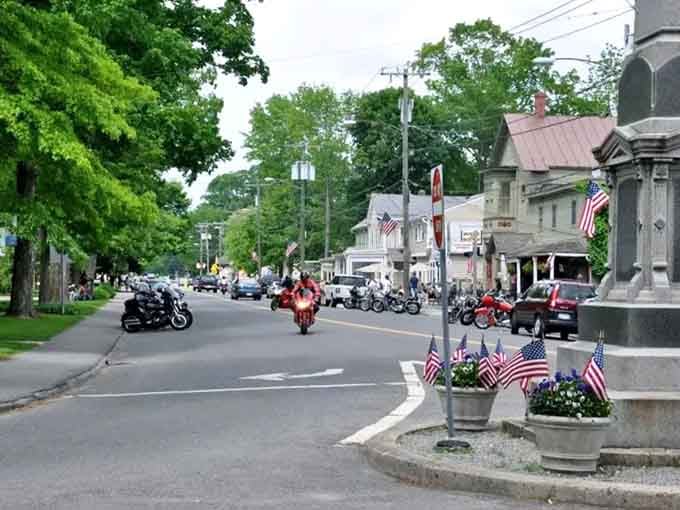 Summer brings motorcycles and memories to this tree-lined street where every flag waves with genuine small-town American pride.