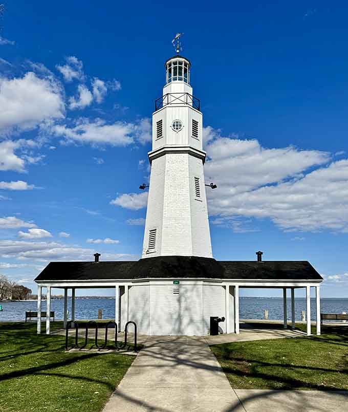 The covered pavilion at its base provides shade while the towering white column above reaches confidently toward the clouds.