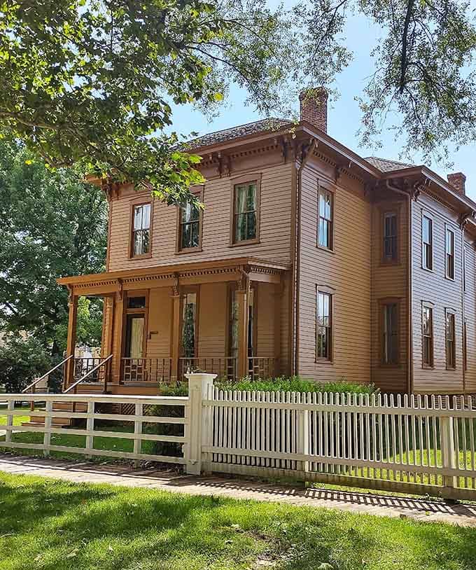 Dappled sunlight filters through mature trees surrounding this historic house, where neighbors once chatted over white picket fences.
