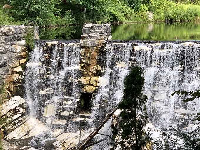Water cascades over layered rock in perfect harmony, creating a scene that soothes the soul instantly.