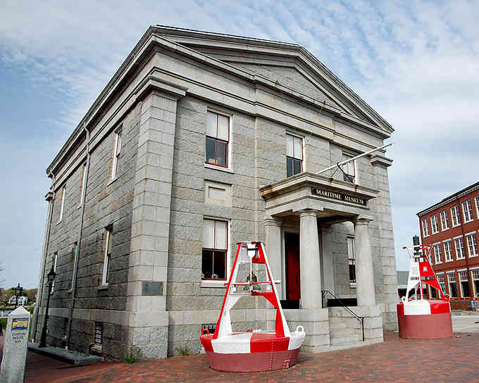 Maritime history lives in this granite structure where a cheerful red boat reminds visitors of seafaring traditions.