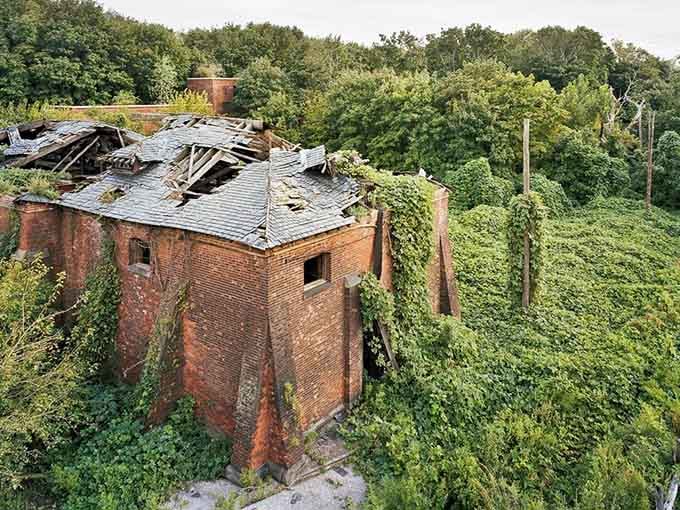 The collapsed roof and overgrown greenery transform abandoned buildings into something resembling a post-apocalyptic movie set.