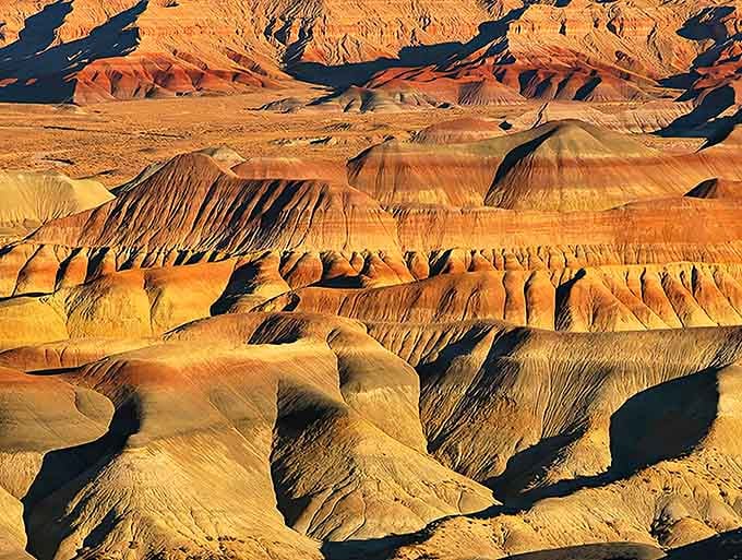 The striped hills stretch endlessly, painted in shades that would make any sunset jealous of the competition.