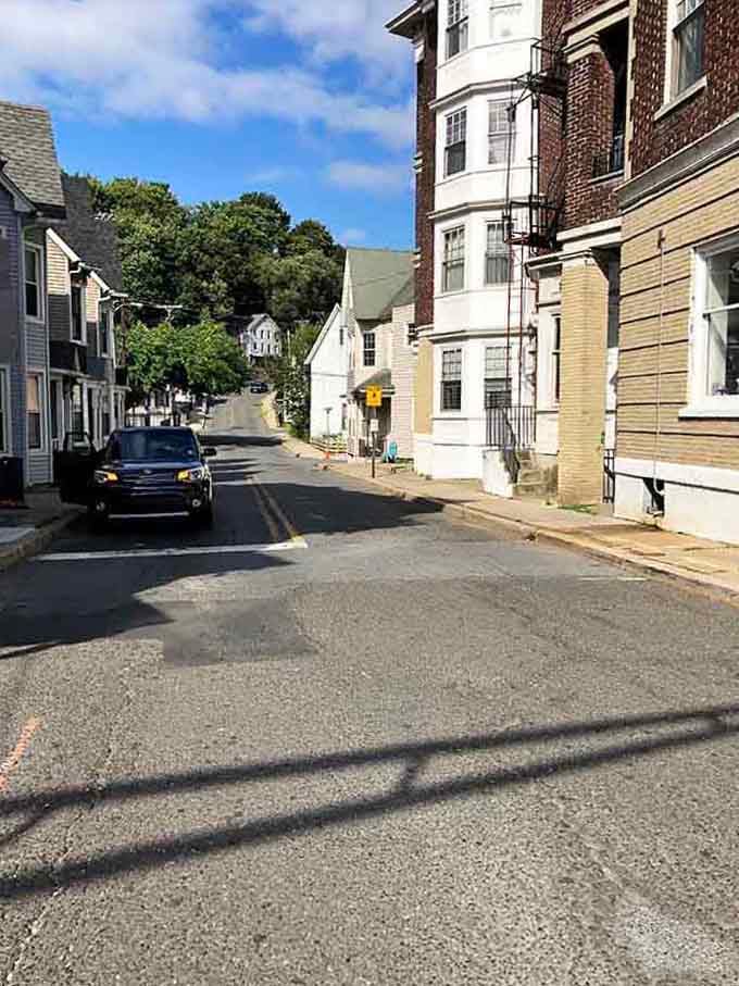 Tree-shaded residential streets like this prove affordable doesn't mean sacrificing the peaceful neighborhood feel you're craving right now.