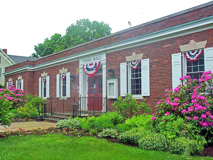 Patriotic bunting decorates Town Hall while azaleas bloom pink, proving small towns still know how to dress up with style.