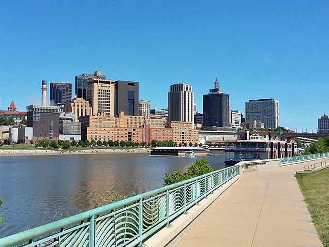 The riverfront path invites leisurely strolls where the only decision is whether to watch boats or admire the architecture.