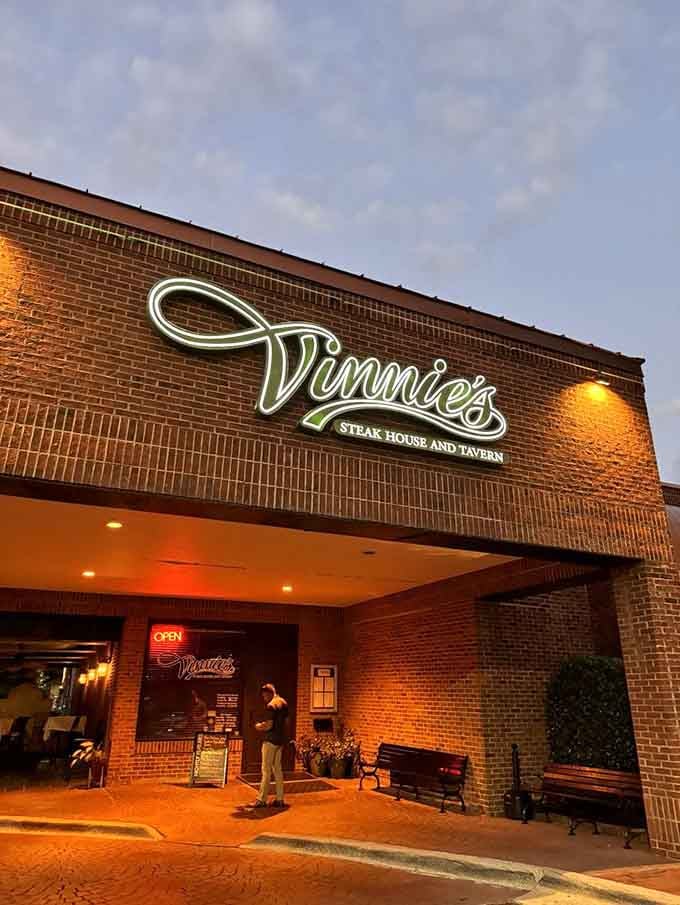 As twilight falls, the warm brick facade and glowing neon sign create an irresistible beacon for hungry steak lovers everywhere.