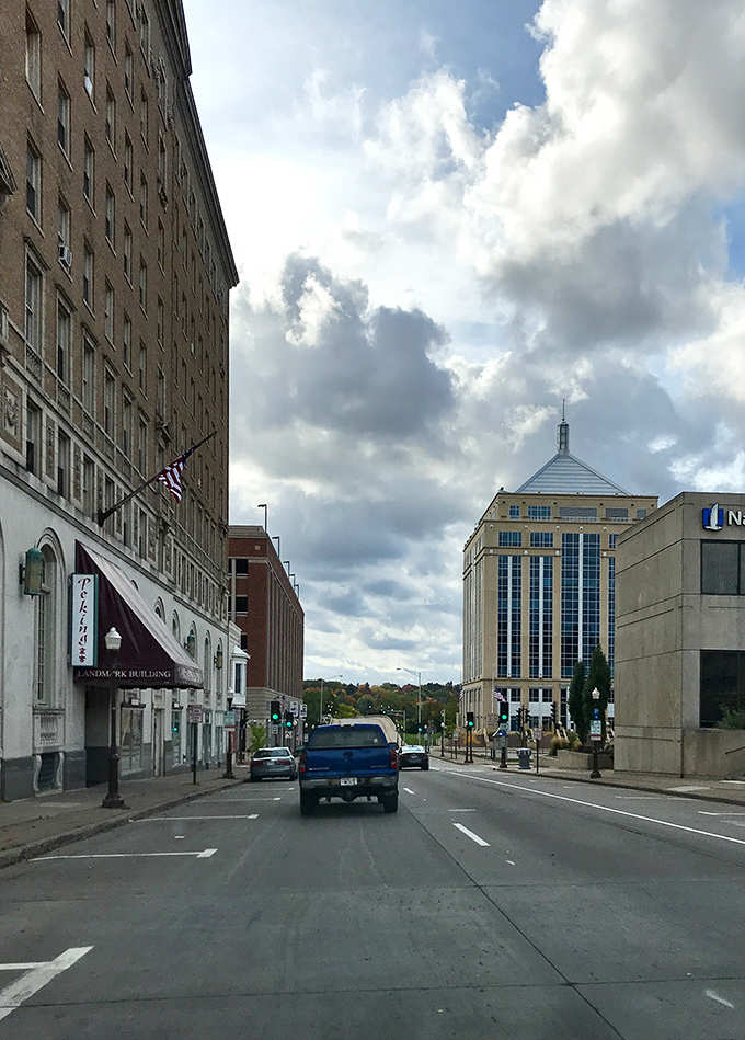 Dramatic clouds frame a street view where classic and contemporary buildings coexist in surprising harmony.