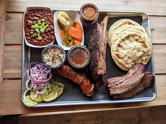 A full tray of smoked meats, beans, and all the fixings: basically a barbecue lover's treasure chest.