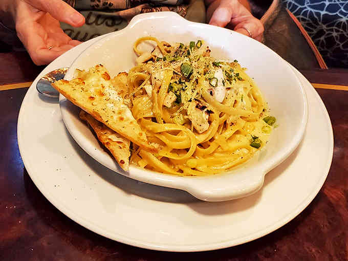 Creamy fettuccine Alfredo with garlic bread offers comfort food perfection for those skipping the seafood route.