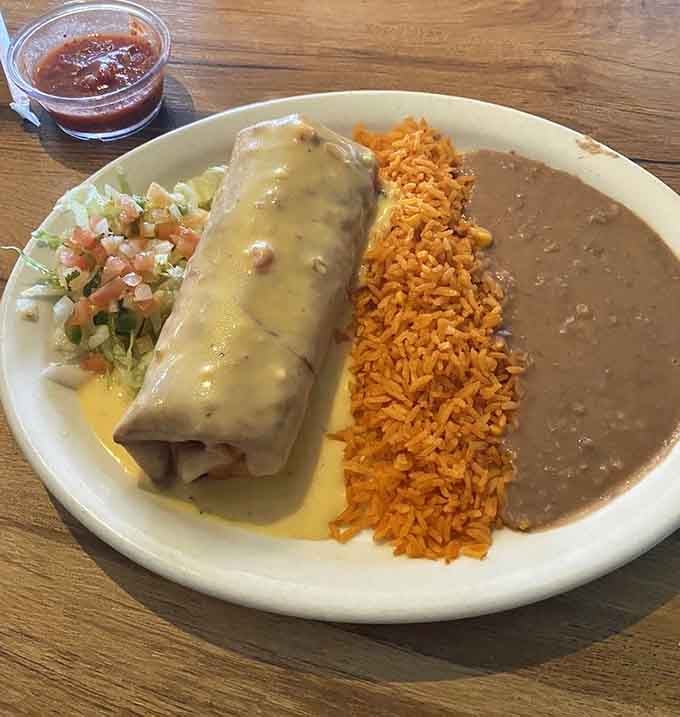 Golden and crispy, this chimichanga sits proudly next to perfectly seasoned rice that's fluffier than a cloud in July.