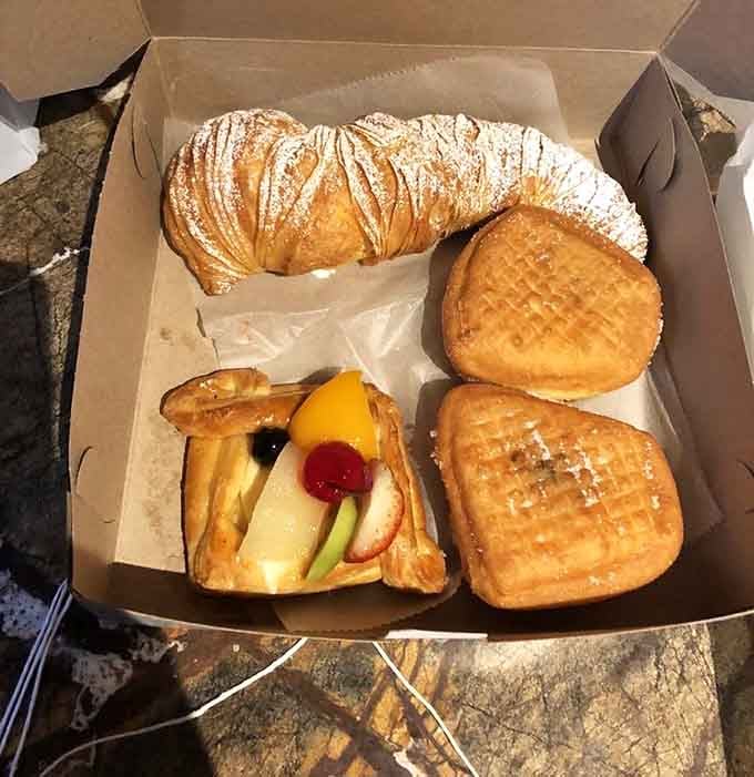 Fresh jelly donuts, croissants, and fruit tarts arranged like edible architecture that won't last long once word gets out.
