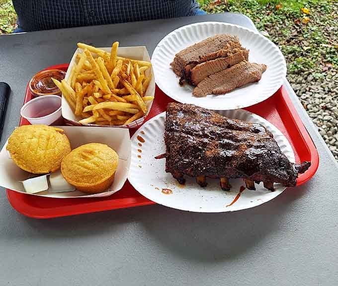 Red trays loaded with ribs, sliced brisket, and golden cornbread create a barbecue spread worthy of Sunday dinner at grandma's house.