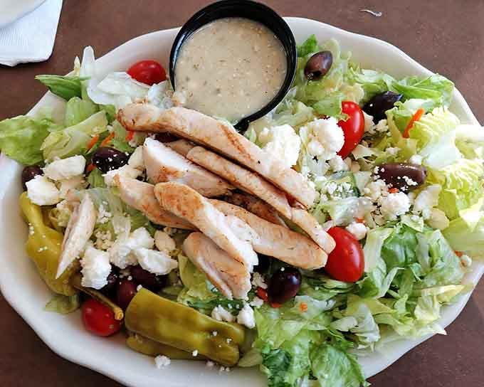 Greek salad loaded with grilled chicken, feta, olives, and peppers that actually taste like real vegetables grew them.