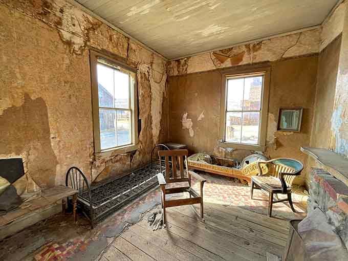 Peeling wallpaper and abandoned furniture create an eerie snapshot of domestic life interrupted, like everyone just walked away mid-conversation.