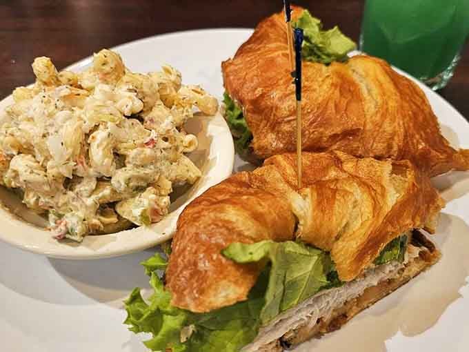 A croissant sandwich with pasta salad proves that carbs supporting other carbs is actually a brilliant life philosophy.