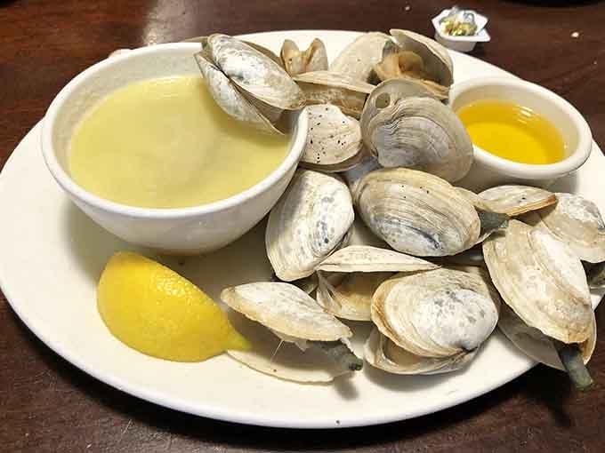 Fresh clams served with drawn butter and broth, ready to transport you straight to seafood heaven with every bite.