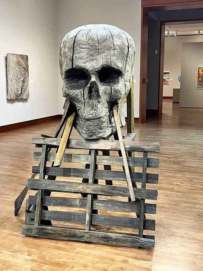 A monumental skull contemplates eternity from its wooden throne, making memento mori surprisingly approachable and thought-provoking.
