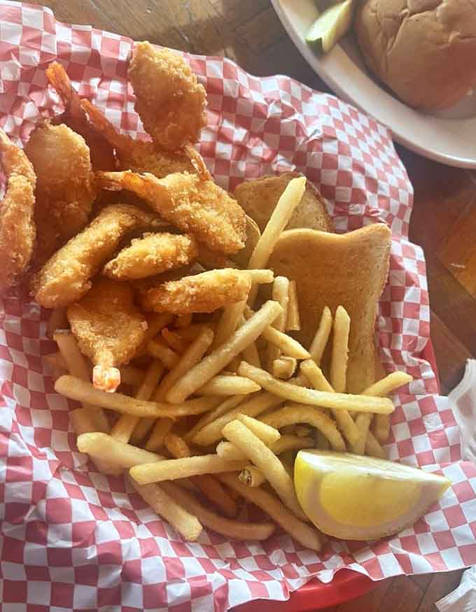 Butterflied shrimp arrive golden and crispy alongside fries, delivering that satisfying crunch with every single bite you take.