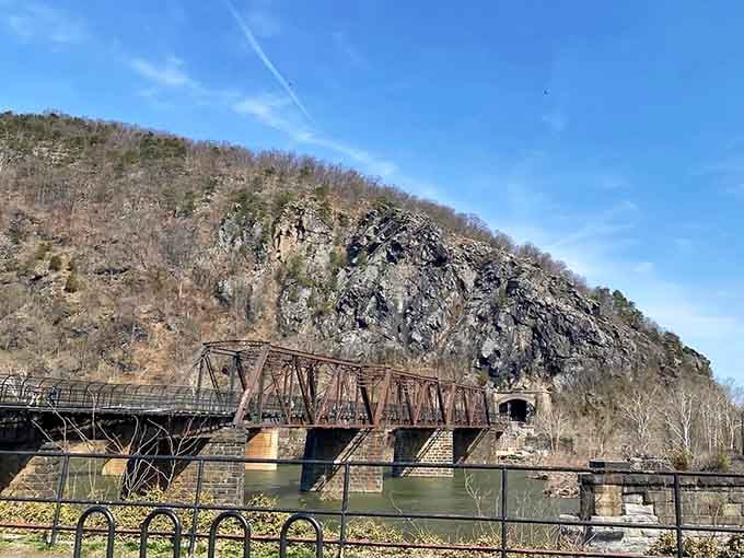 Maryland's cliffs rising above the Potomac like nature's own cathedral, complete with railroad bridge and mountain backdrop drama.