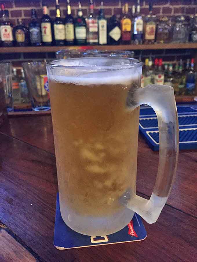 A frosty mug of beer at the bar with bottles lined up behind is pure happiness.