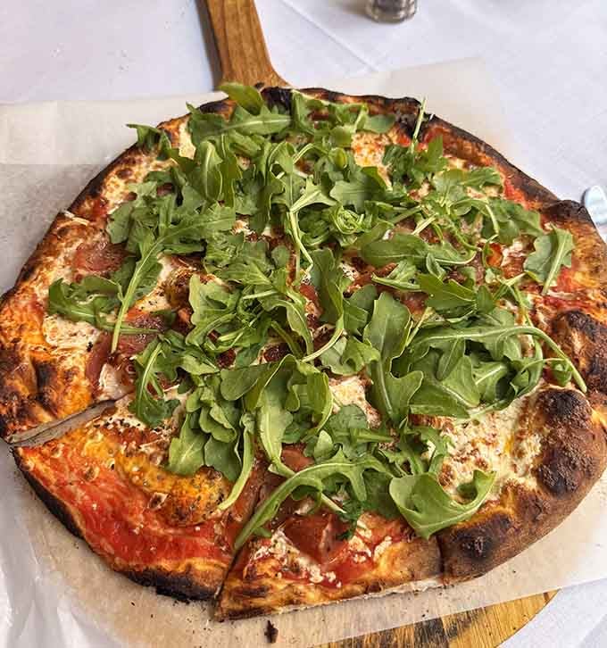 Brick oven pizza topped with fresh arugula brings that perfect char and peppery bite worth fighting over the last slice.