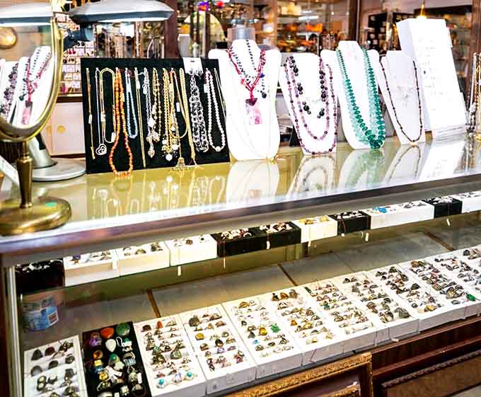 Sparkling necklaces and vintage brooches catch the light, each piece once adorning someone's special occasion or everyday elegance.