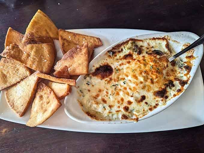Golden, bubbling spinach artichoke dip with crispy pita chips is basically edible happiness in a hot dish.