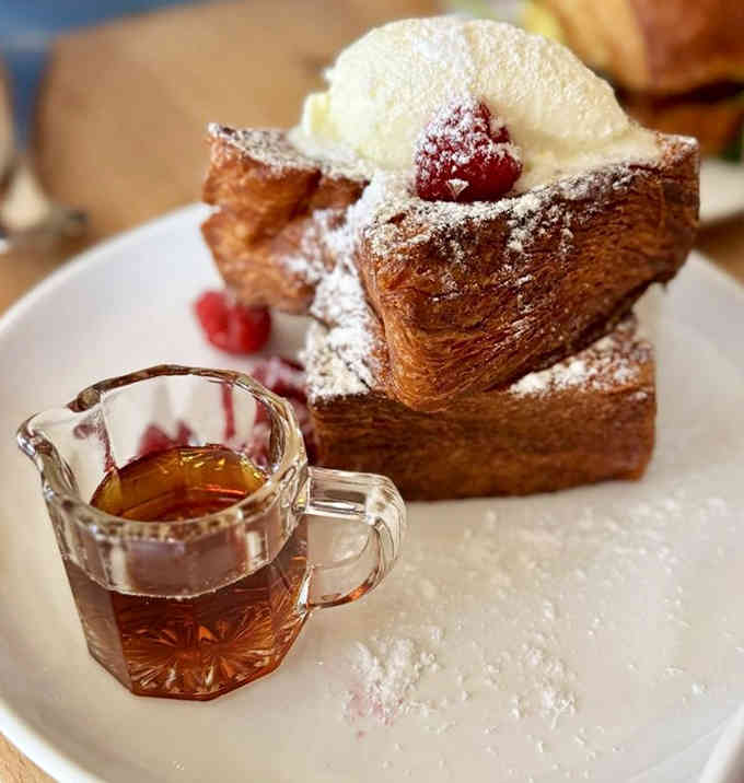French toast stacked high with powdered sugar and berries, because sometimes breakfast needs to look like a celebration.