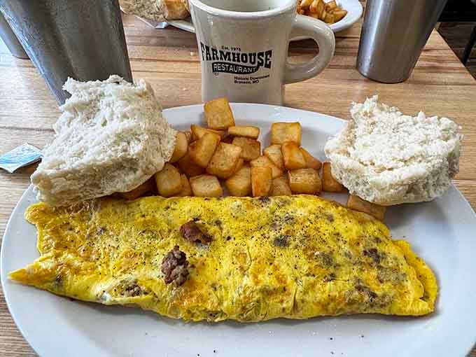 That omelet is stuffed fuller than a Thanksgiving turkey, with biscuits standing guard on the side.