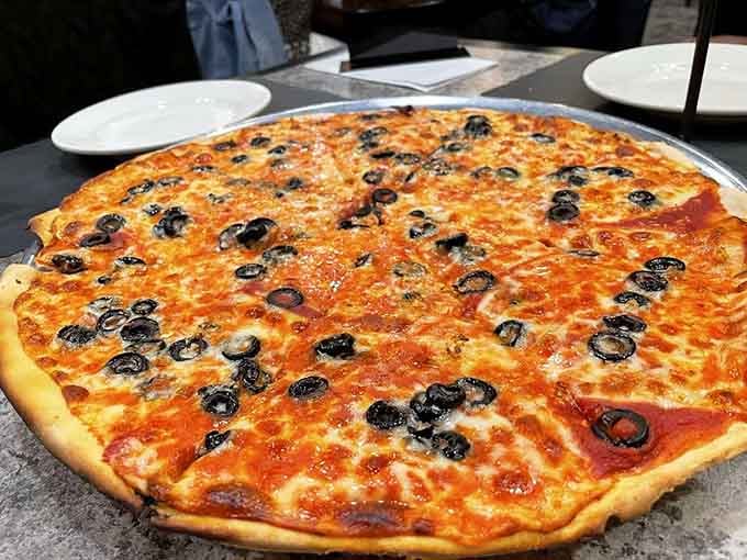 Black olives scattered across melted cheese like edible confetti, proving that sometimes simple toppings create the most satisfying combinations.