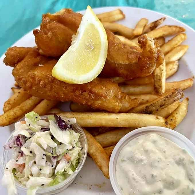 Crispy fish, seasoned fries, and creamy coleslaw form the holy trinity of coastal comfort food done right.