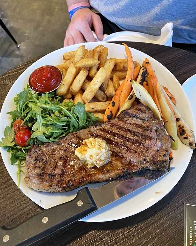 That New York strip comes with fries, vegetables, and the kind of presentation that makes you pause before diving in hungrily.