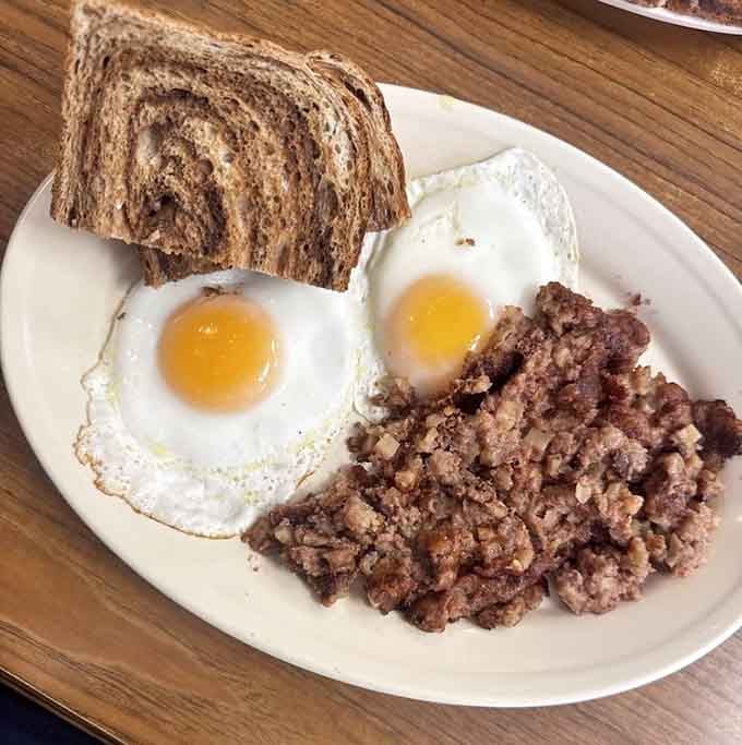 Corned beef hash with perfectly fried eggs and marbled rye toast: the breakfast that built America, still going strong.