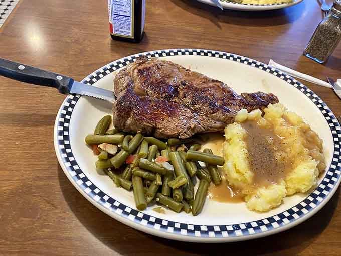 A perfectly cooked ribeye with green beans and mashed potatoes&mdash;this is comfort on a checkered plate.