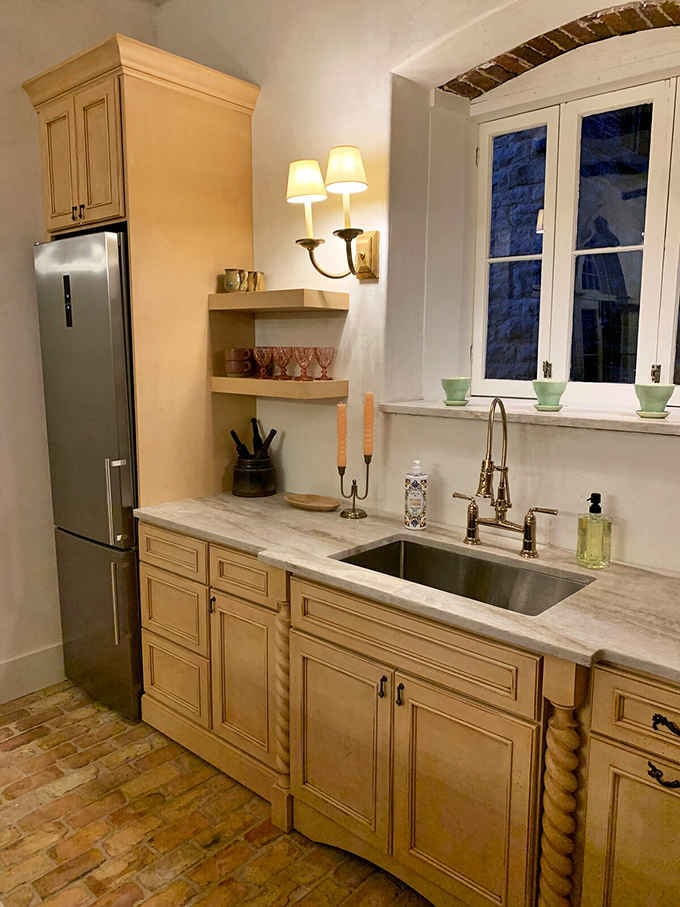 Marble countertops meet vintage fixtures in a kitchen where modern convenience bows gracefully to timeless style.